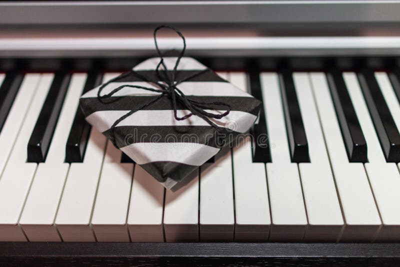 Gift Box in a Striped Black and White Packaging on the Piano Keyboard ...