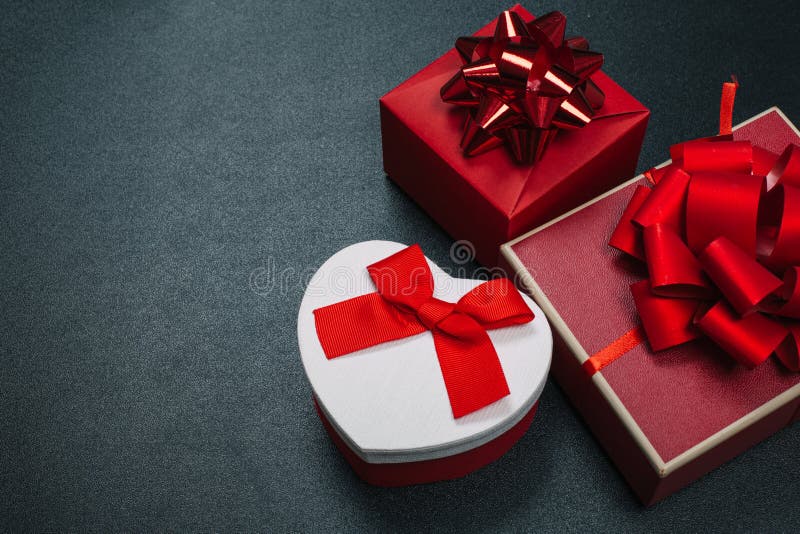 Gift Box Wrapped in Paper with Red Ribbon on Black Surface. Top View ...