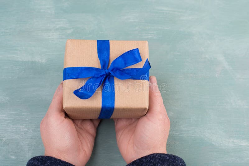 Holding a Gift Box in the Hands, Blue Colored Background Stock Image ...