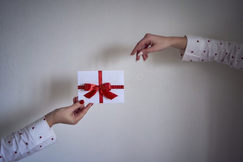 A Gift Certificate in Red and White Colors in Female Hands on a White ...