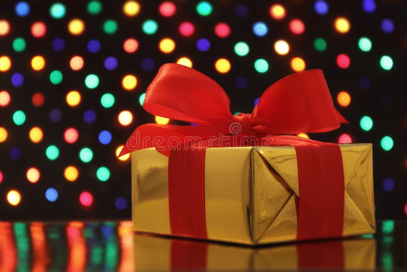 Gift Wrapped Present with a Bow in Front of a Festive Garland Lights ...