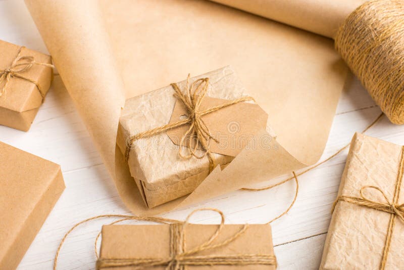 Gifts from Kraft Paper on White Table with Threads and a Roll. Stock ...