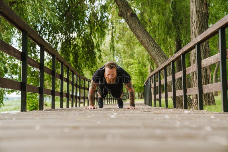 Ginger Bearded Sportsman Doing Exercise while Working Out in Park Stock ...