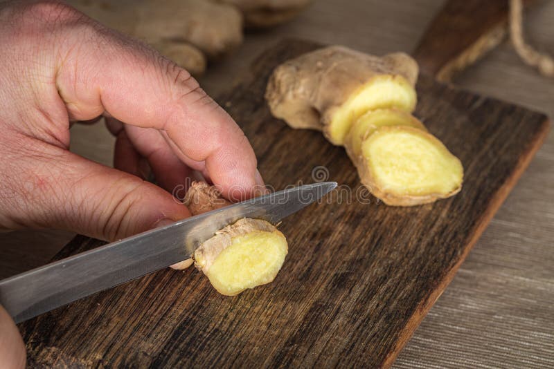 Ginger Cut with a Knife on a Chopping Board in the Kitchen Stock Photo ...