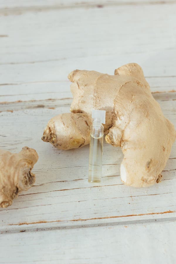 Ginger Essential Oil in Glass Bottle with Ginger Root Behind. Stock ...