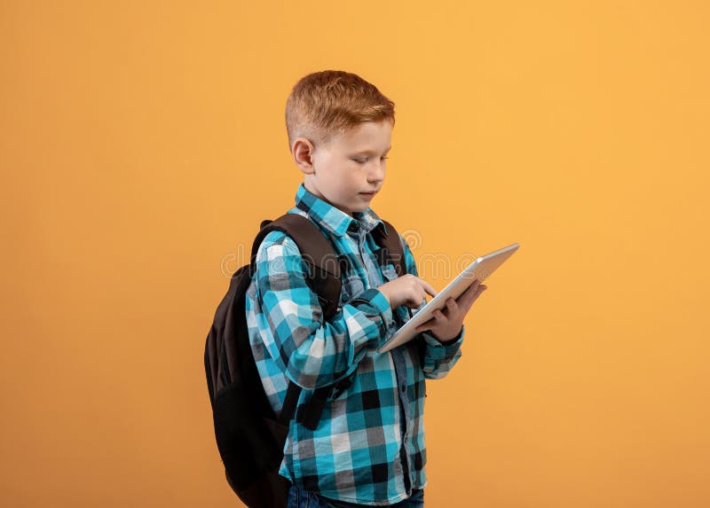 Ginger Kid Schooler Using Digital Tablet on Yellow Stock Image - Image ...
