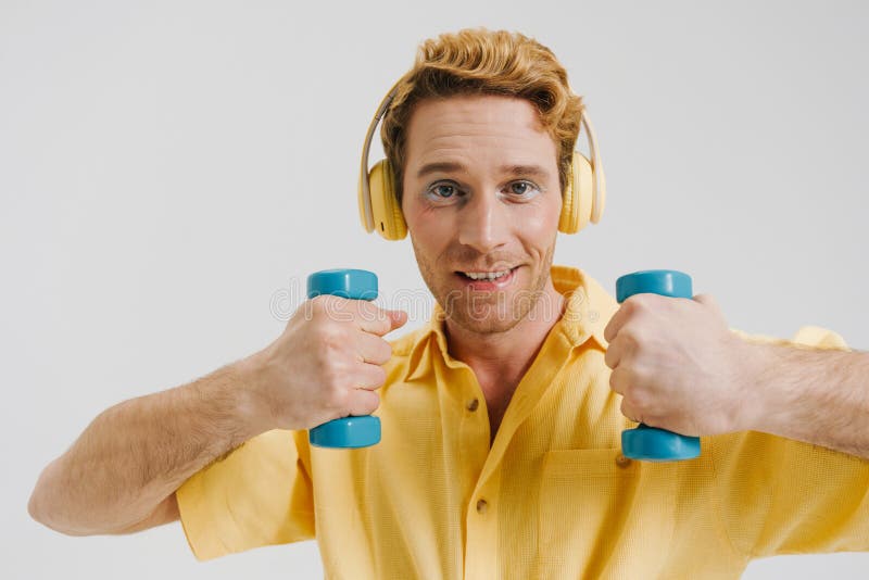 Ginger Man in Headphones Smiling while Doing Exercise with Dumbbells ...