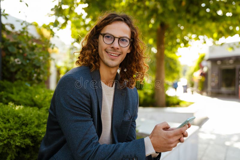 Ginger Man Talking on Mobile Phone while Sitting in Summer Park Stock ...