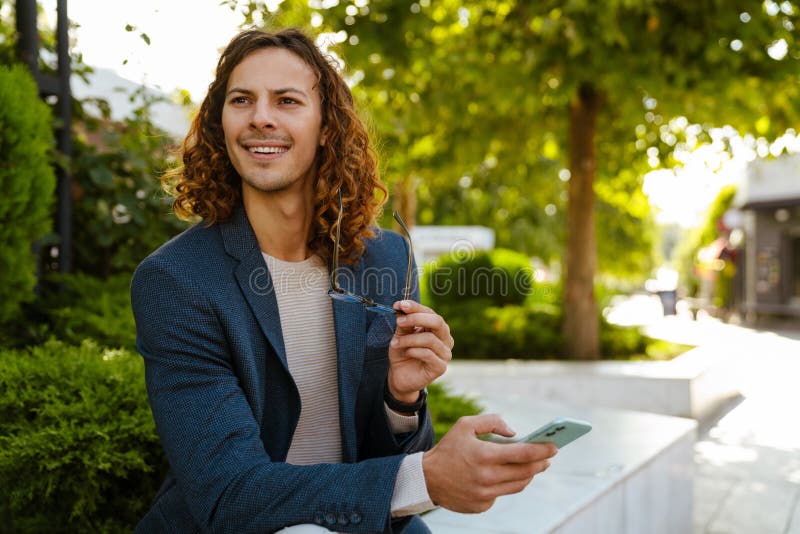 Ginger Man Talking on Mobile Phone while Sitting in Summer Park Stock ...