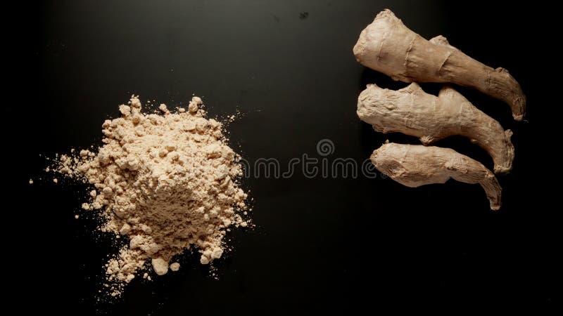 Ginger Powder and Ginger Roots on the Black Table, Top View Stock Photo ...