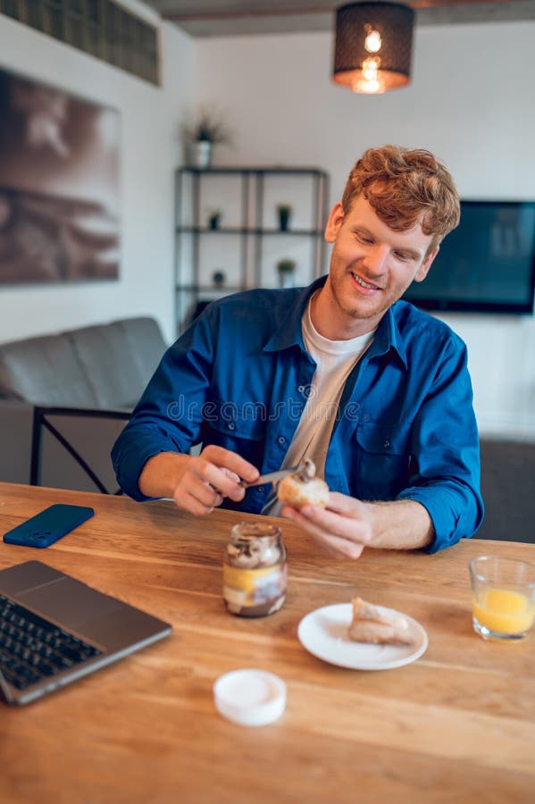 Ginger Young Man Sitting in Th Kitchen and Making Sandwich with ...