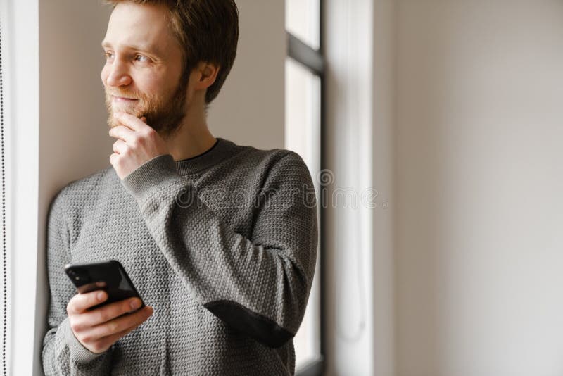 Ginger Young Man Using Mobile Phone while Leaning on Wall Stock Image ...