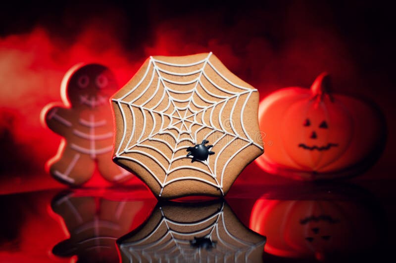 A Gingerbread Cookie Decorated with a White Icing Spider Web and a ...