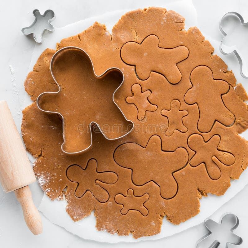 Gingerbread Dough Being Cut into Gingerbread Men with Cookie Cutters ...