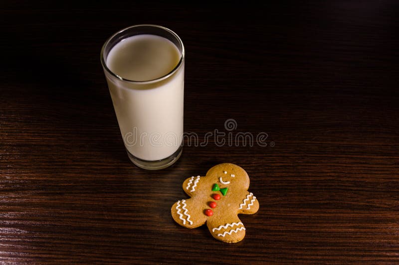 Gingerbread Man and a Glass of Milk on a Dark Wooden Table Stock Photo ...