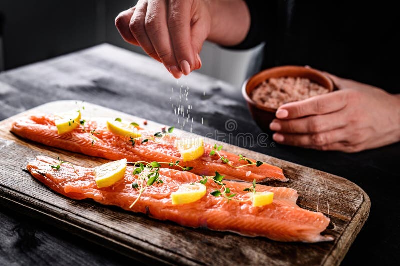 Girl Adding a Pinch of Salt To Raw Red Trout Fish Stock Image - Image ...