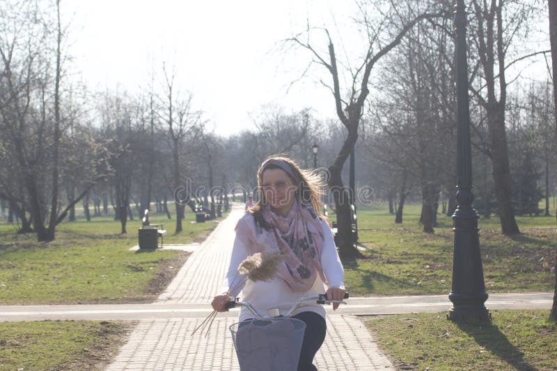 Girl on a Bike Ride in a Spring Park. Stands with a Bike Stock Image ...