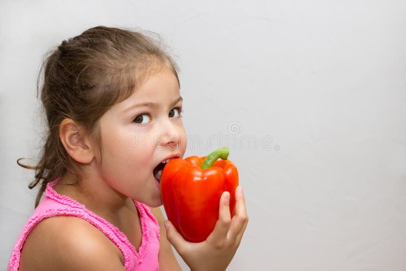 Girl biting into a pepper stock photo. Image of laughing - 46146882