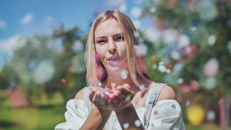 A Girl Blows A Multi Coloured Paper Confetti Out Of Her Hands Stock