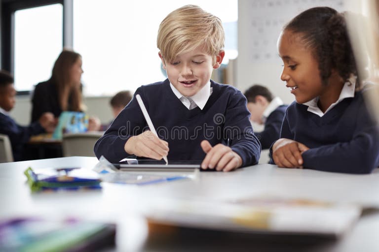 A Girl and a Boy Using a Tablet Computer and Stylus in a Primary School ...