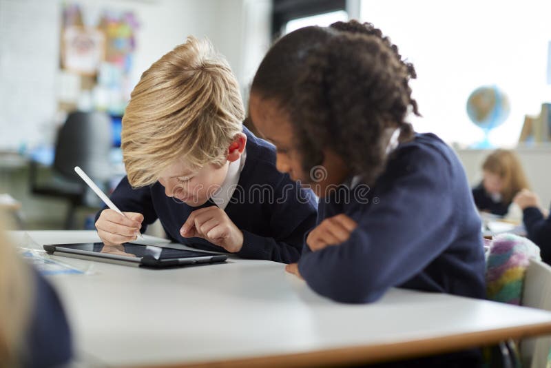 A Girl and a Boy Using a Tablet Computer and Stylus in a Primary School ...