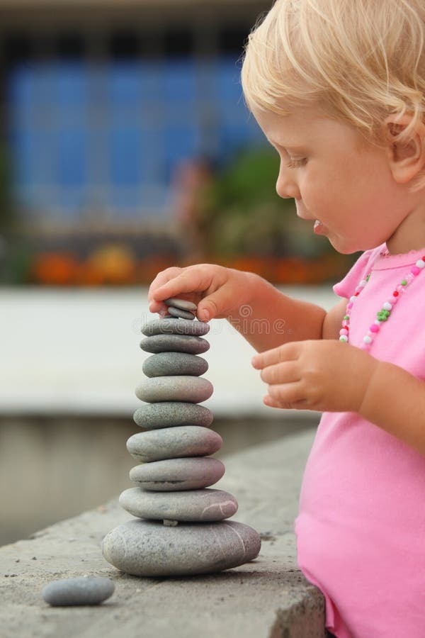 Girl is Building a Construction from Pebble Stones Stock Photo - Image ...