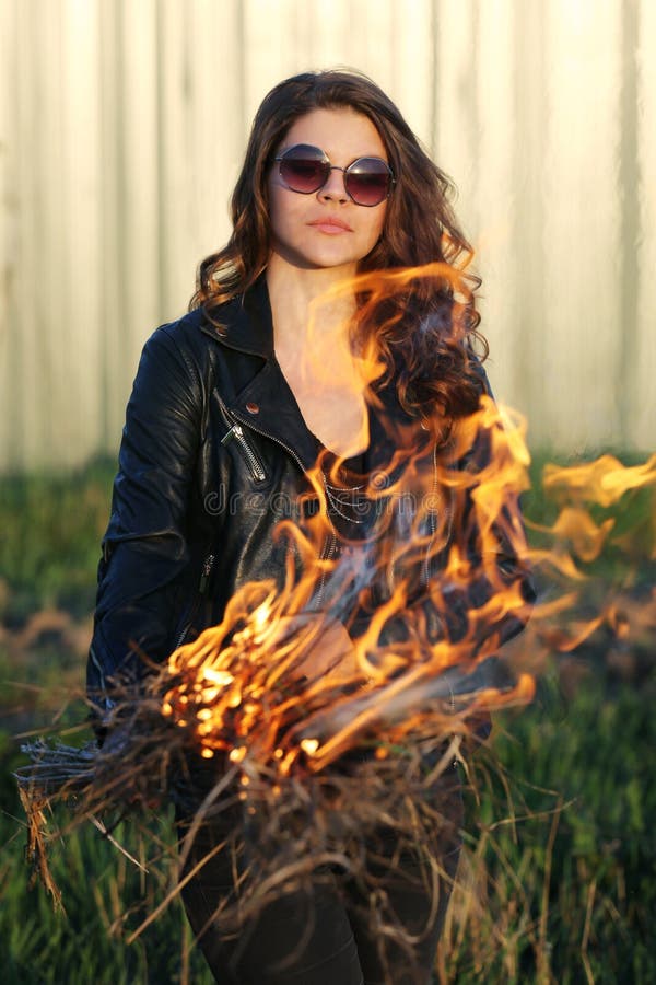 Girl Bully Standing in a Black Jacket is a Fire in Their Hands Outdoors ...