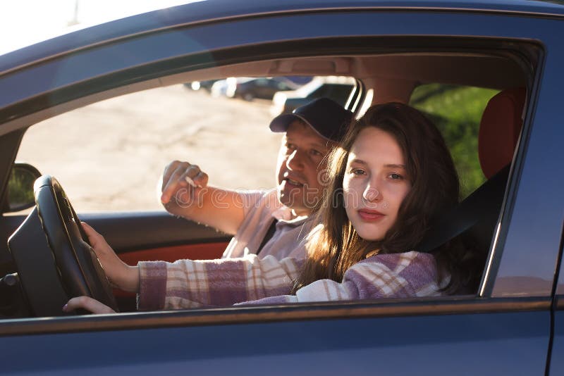 A Girl in a Car with a Driving Instructor. Training and Driving a Car ...