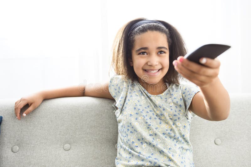 Girl Changing Channel with Remote Control in Front of Television at ...
