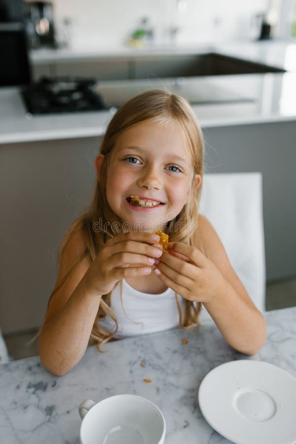 Girl Child Eating a Piece of Pie at the Table in the Kitchen in the ...