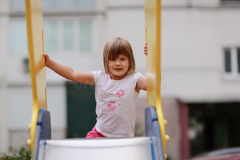 The Girl Climbs Up the Slide at the Playground Stock Photo - Image of ...