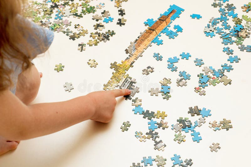 Girl Collects a Puzzle from Small Pieces Stock Photo - Image of ...