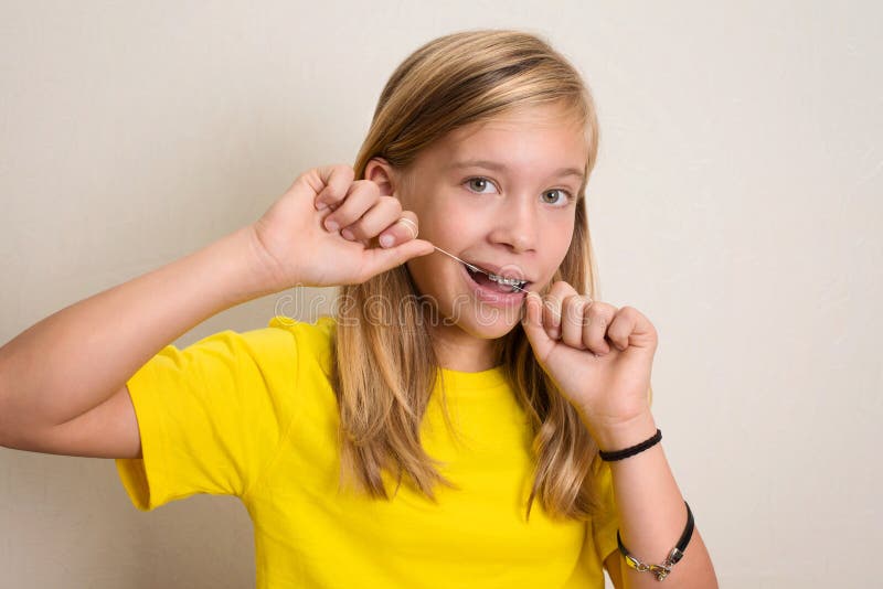 Girl With Dental Braces Flossing Teeth. Close-up Portrait Of Pre Teen ... Girl With Dental Braces Flossing Teeth. Close-up Portrait Of Pre Teen ...