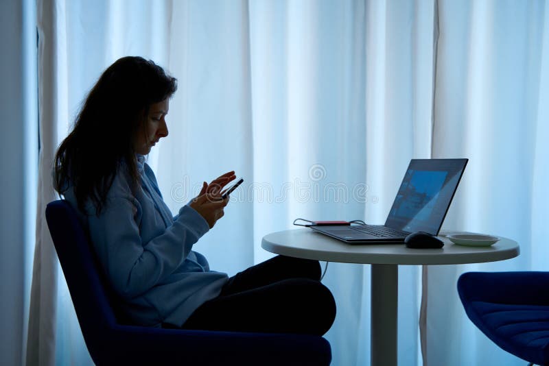 The Girl is Distracted by the Phone at the Workplace at the Computer ...