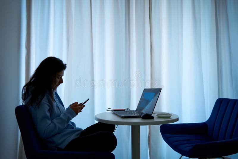 The Girl is Distracted by the Phone at the Workplace at the Computer ...