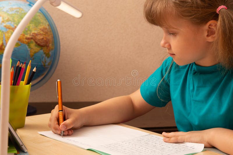 A Girl Does a Home Remote Task, Homework in the Evening Stock Photo ...