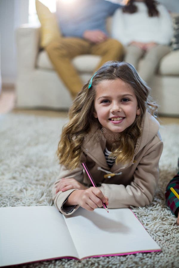 Girl Doing Homework while Lying on the Floor Stock Image - Image of ...