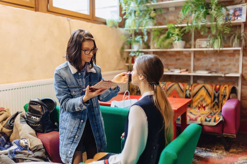 Girl doing make up in cafe stock photo. Image of person - 146860626
