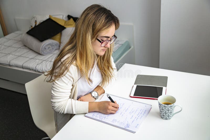 Girl Doing Notes on Paper Sitting at Table in Room Stock Image - Image ...