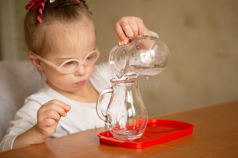 Girl with Down Syndrome Learns To Pour Water from Pitcher To Pitcher ...