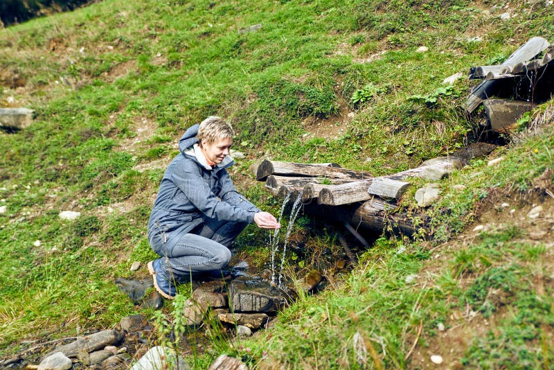 Girl Drinks Water from a Mountain Spring Stock Photo - Image of ...