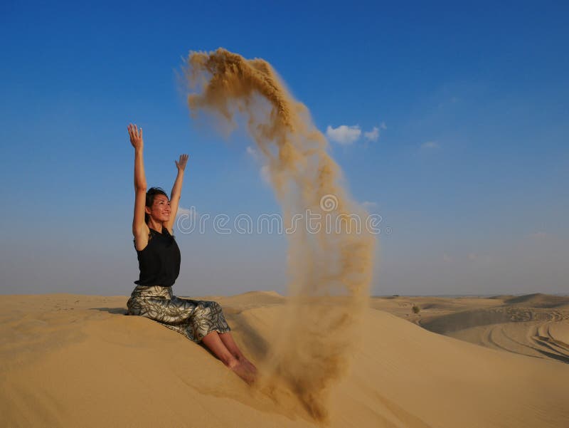A Girl in the Dubai Desert Throws Sand Up and Smiles Stock Photo ...
