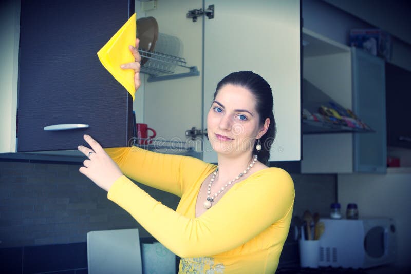 Girl dusting in kitchen stock image. Image of furniture - 76920573