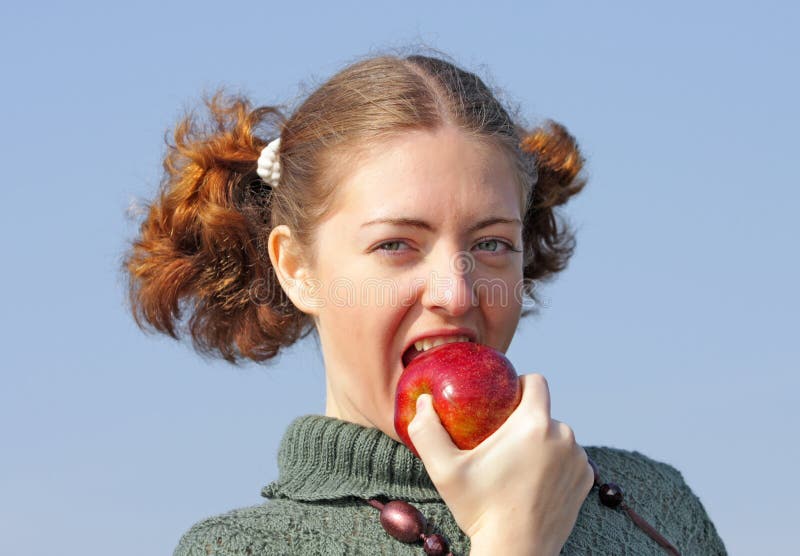 Old-fashioned Young Curly Girl in a Vintage Gray Knitted Dress Bites a ...