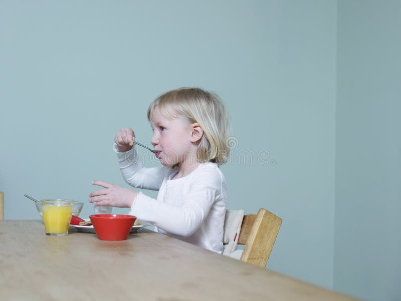 Girl Eating Breakfast at Dining Table Stock Image - Image of domestic ...