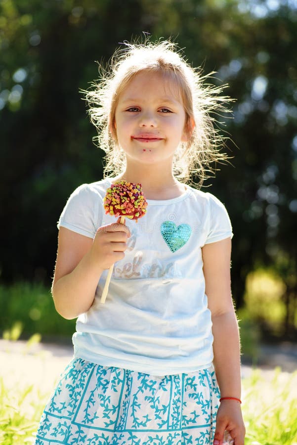 Girl eating candy apple stock photo. Image of child - 142922976