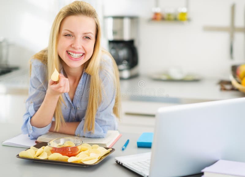 Girl Eating Chips while Studying in Modern Kitchen Stock Photo - Image ...