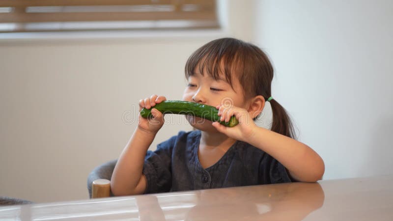 Girl eating cucumber stock footage. Video of nose, toddler - 344450978