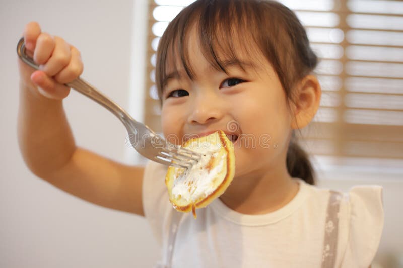 Girl eating hot cake stock image. Image of cute, space - 324603673
