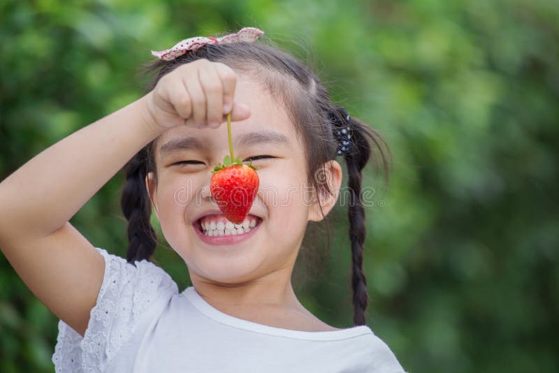 Girl eating strawberries stock photo. Image of happiness - 66581748